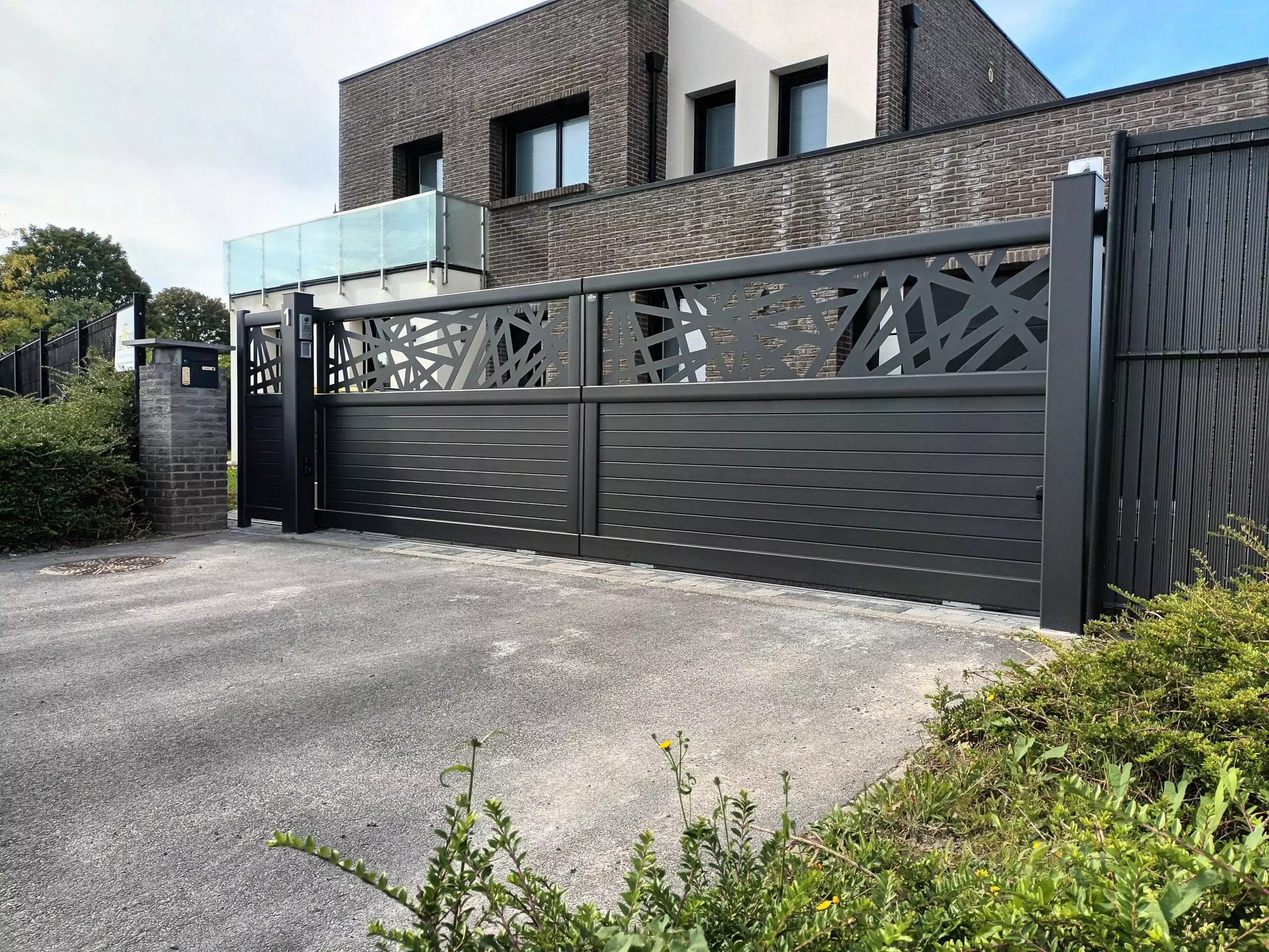Installation d'un portail coulissant avec des décorations sur le haut ...